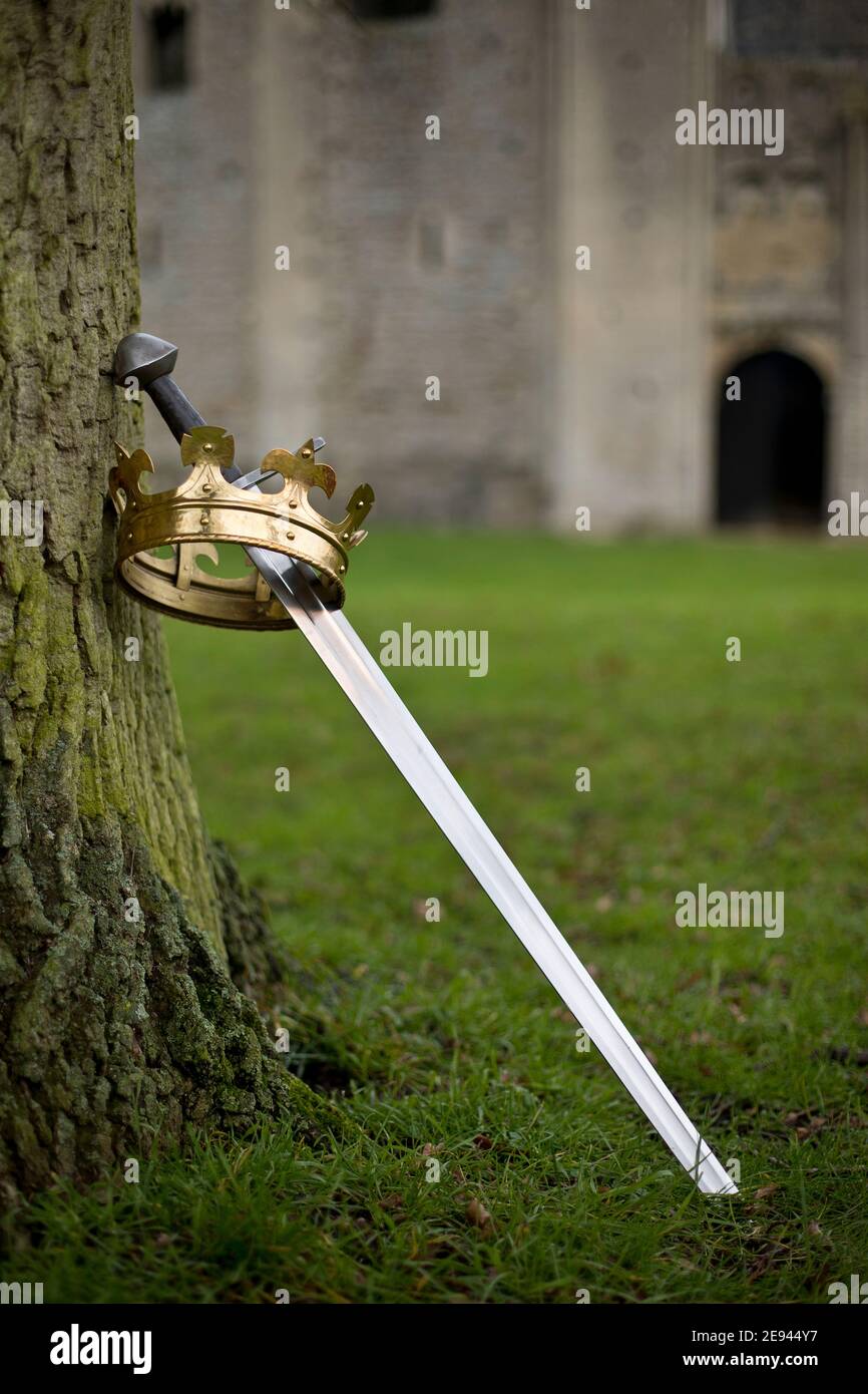 Crown and sword rest against tree outside castle keep Stock Photo - Alamy