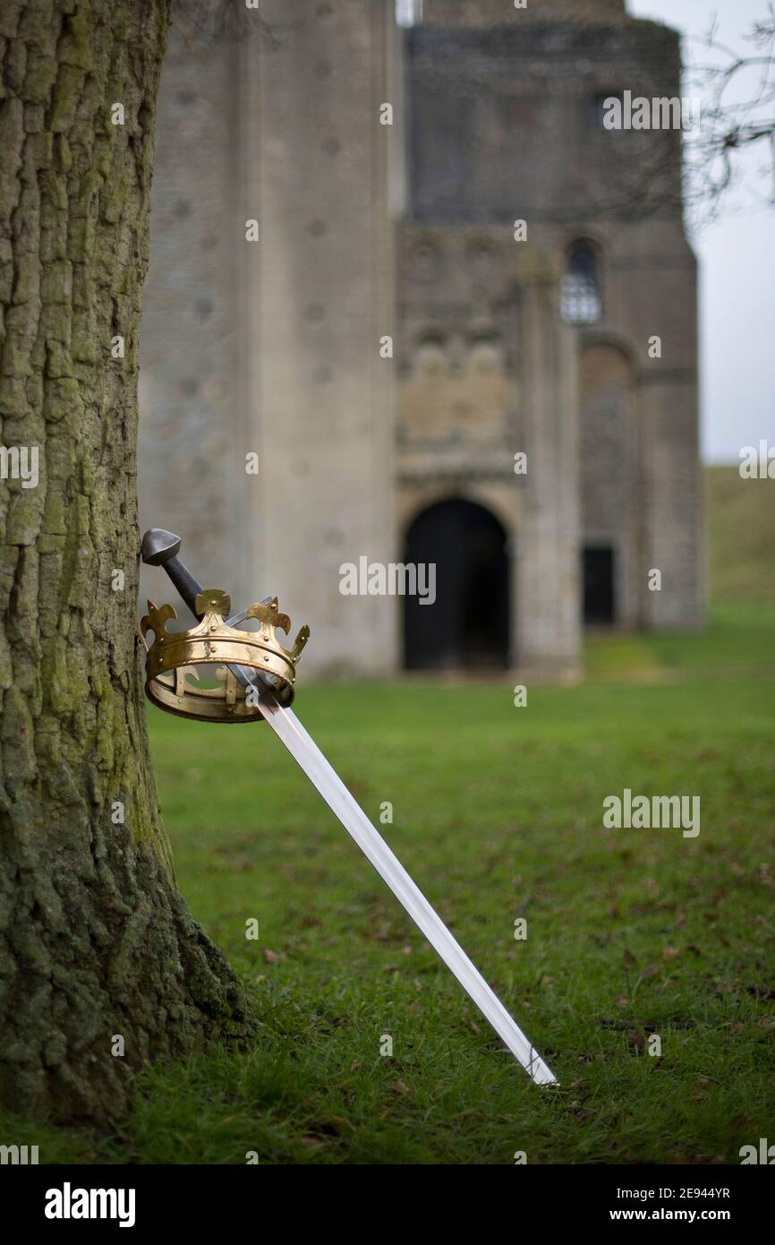 Crown and sword rest against tree outside castle keep Stock Photo - Alamy