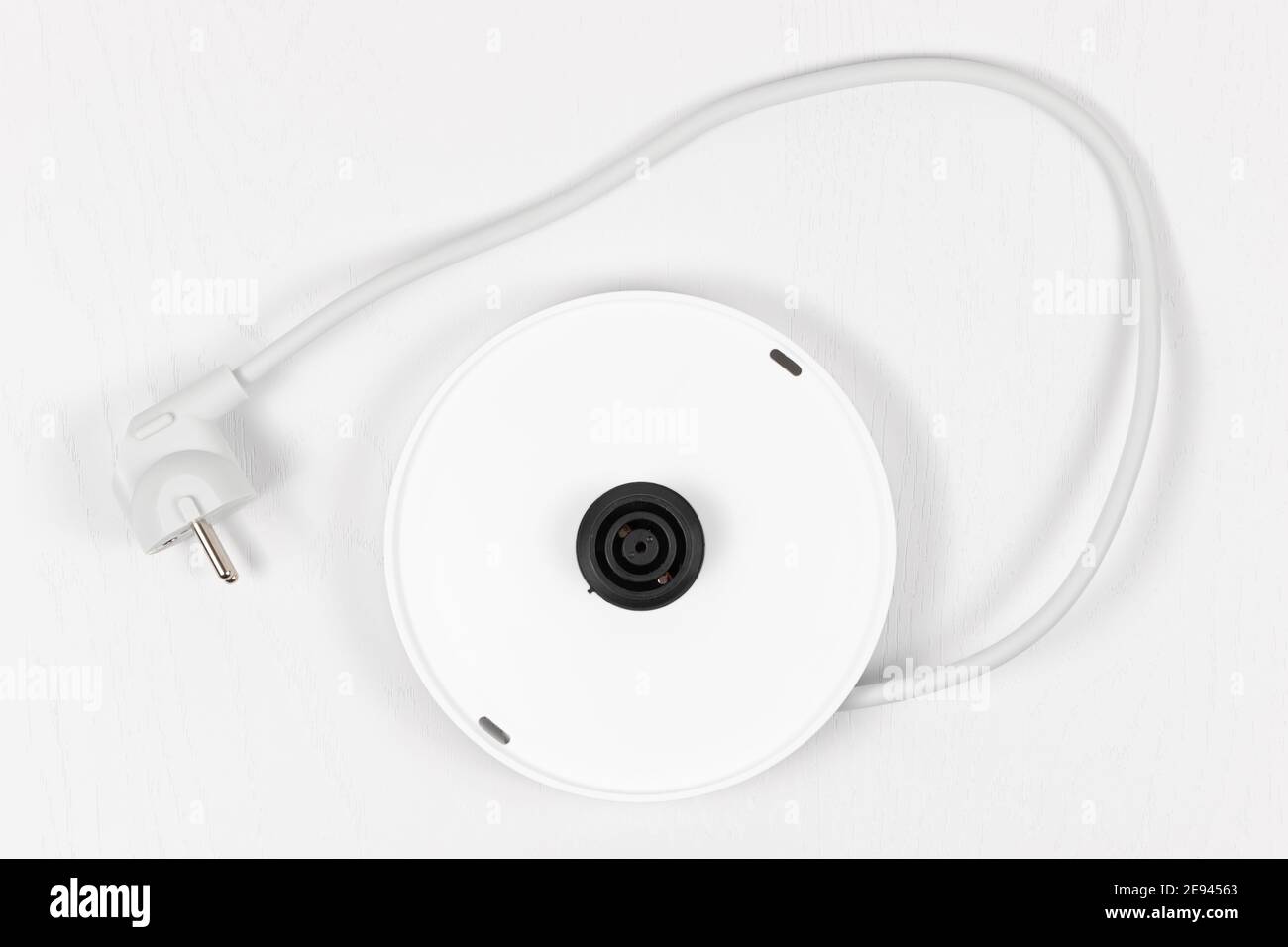 white teapot stand with wire and electric plug on white wooden table ...