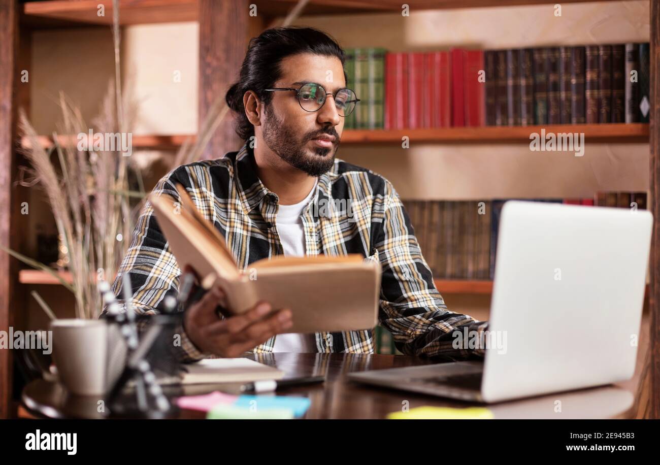 Arab Student Learning Reading Book And Browsing Internet In Library ...
