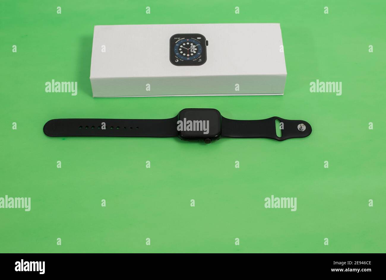Smartwatch and a box isolated on green background Stock Photo - Alamy