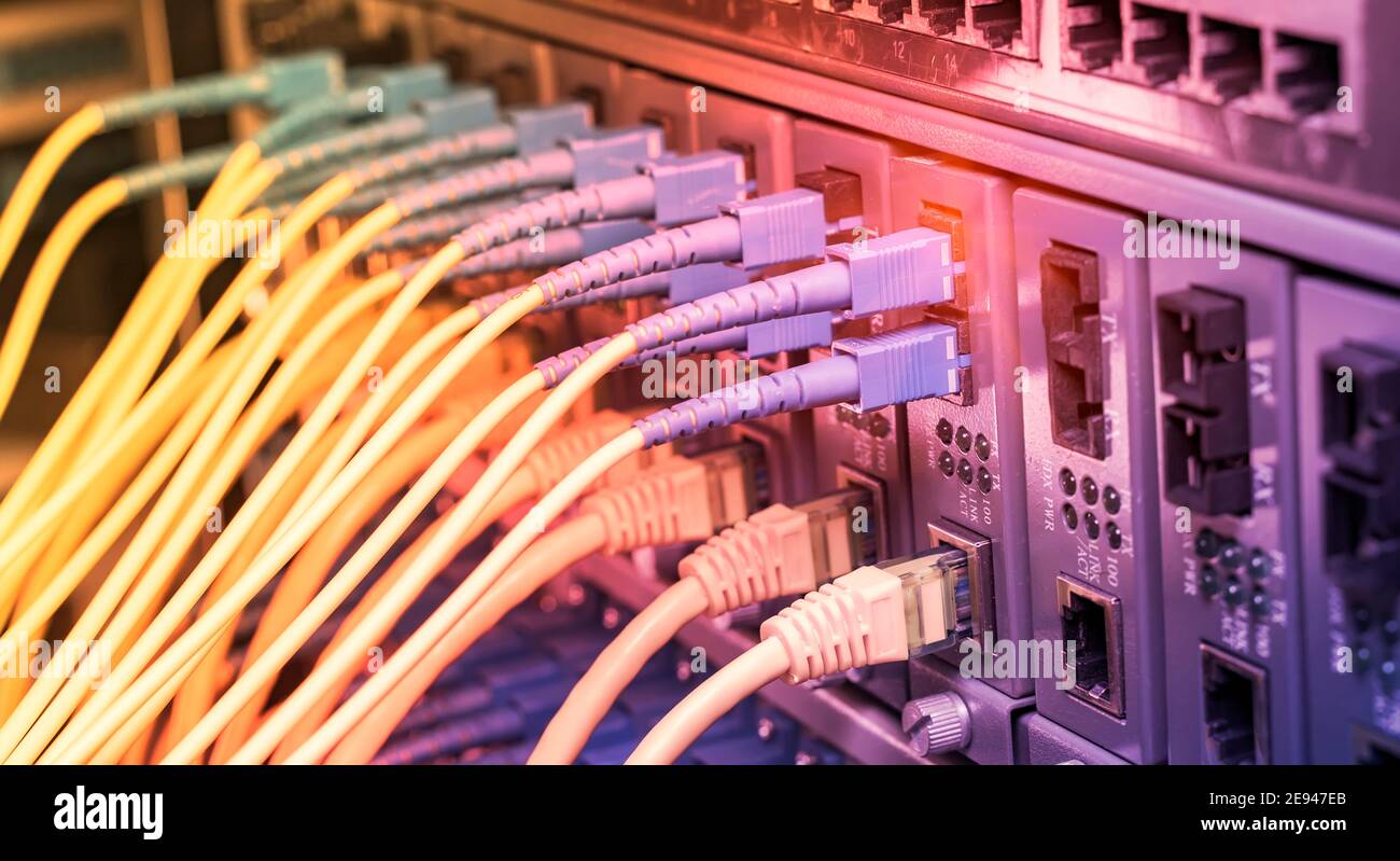 Fiber Optic cables connected to an optic ports and Network cables ...