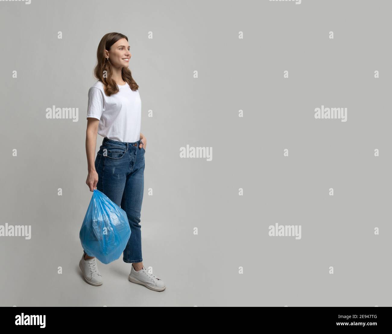 Woman carrying garbage bag hi-res stock photography and images - Alamy