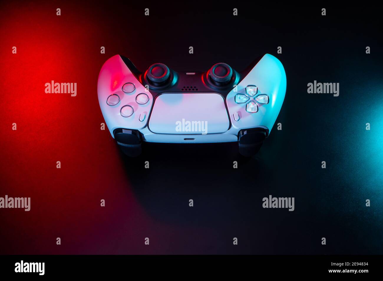 Modern white gamepad illuminated in red and blue. Game controller for ...