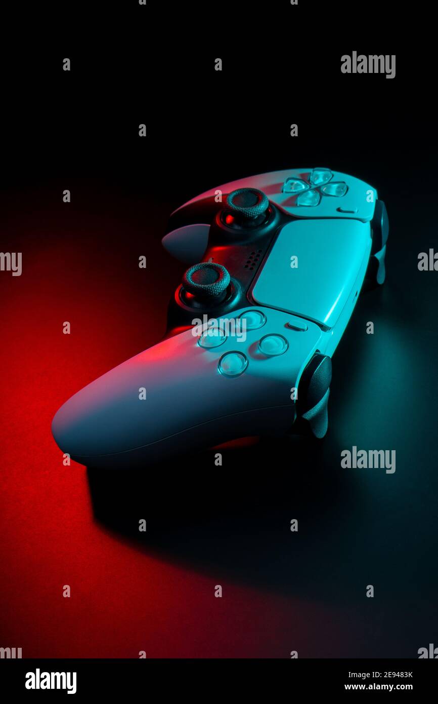Modern white gamepad illuminated in red and blue. Game controller for ...