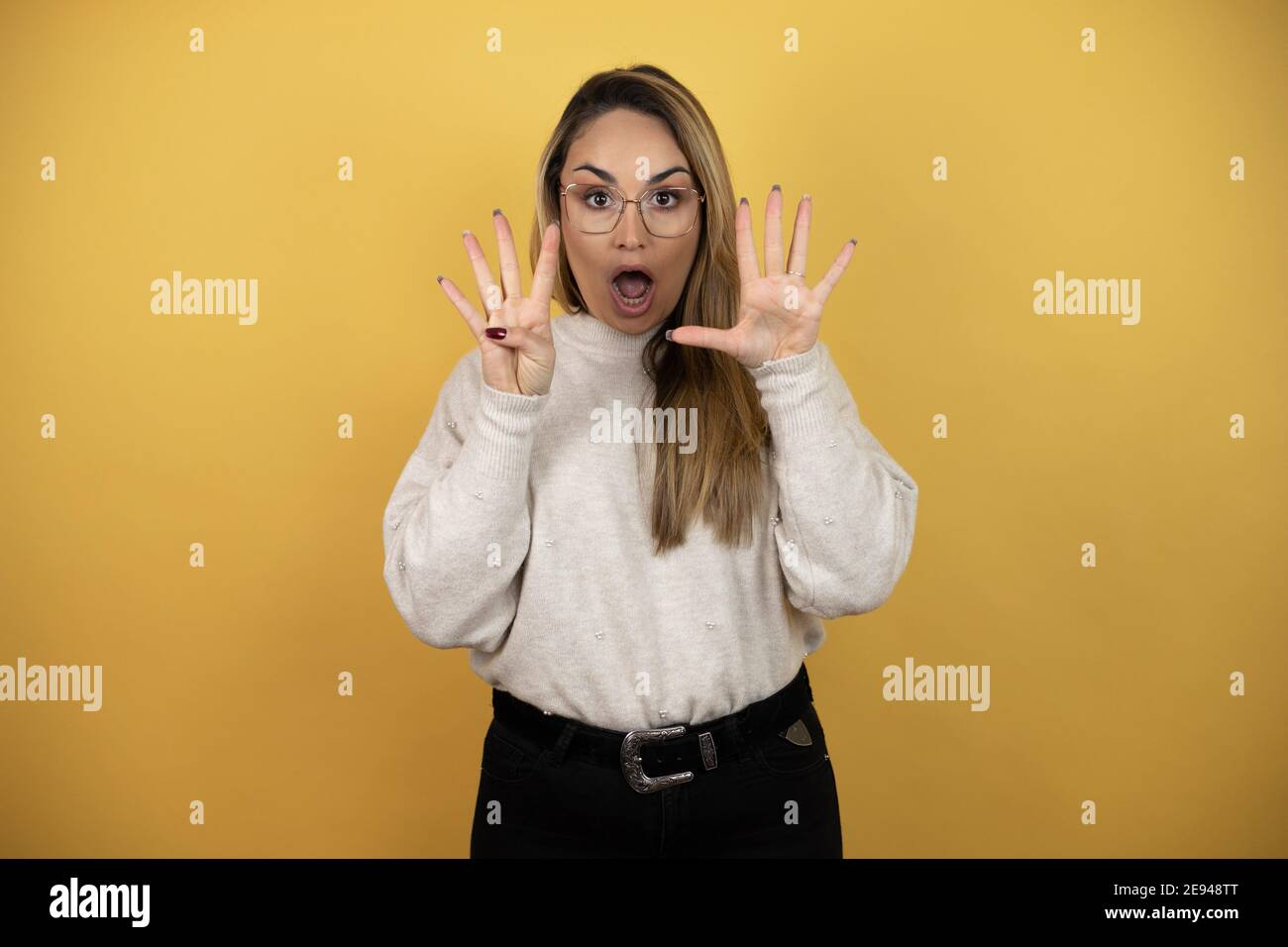 Pretty woman with long hair showing and pointing up with fingers number ...