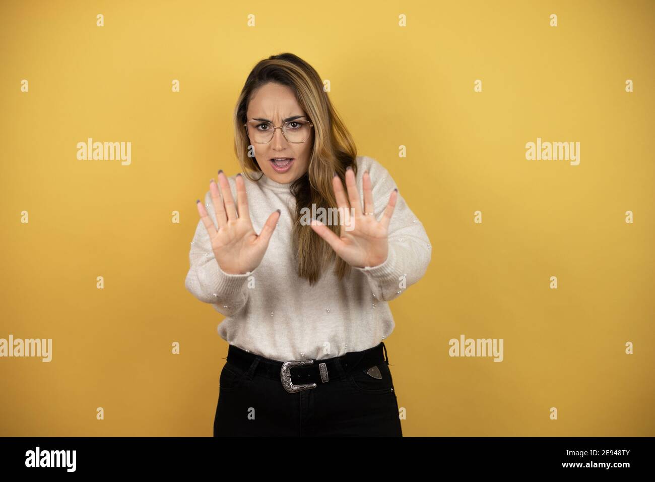 Pretty woman with long hair afraid and terrified with fear expression ...