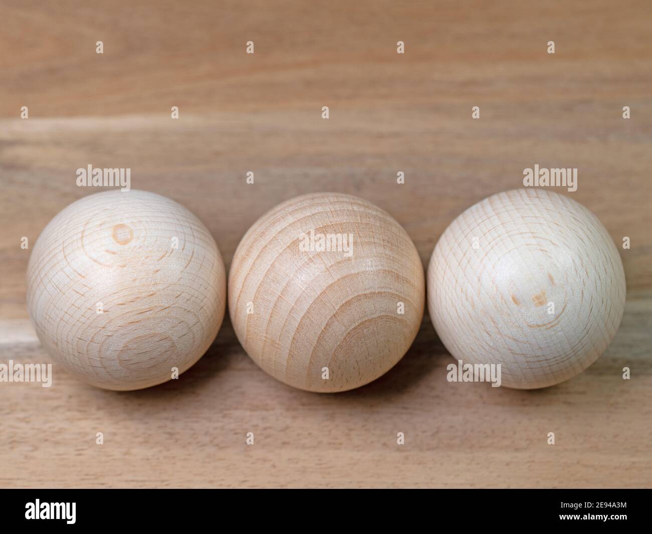 Three wooden balls in front of a wooden background Stock Photo - Alamy