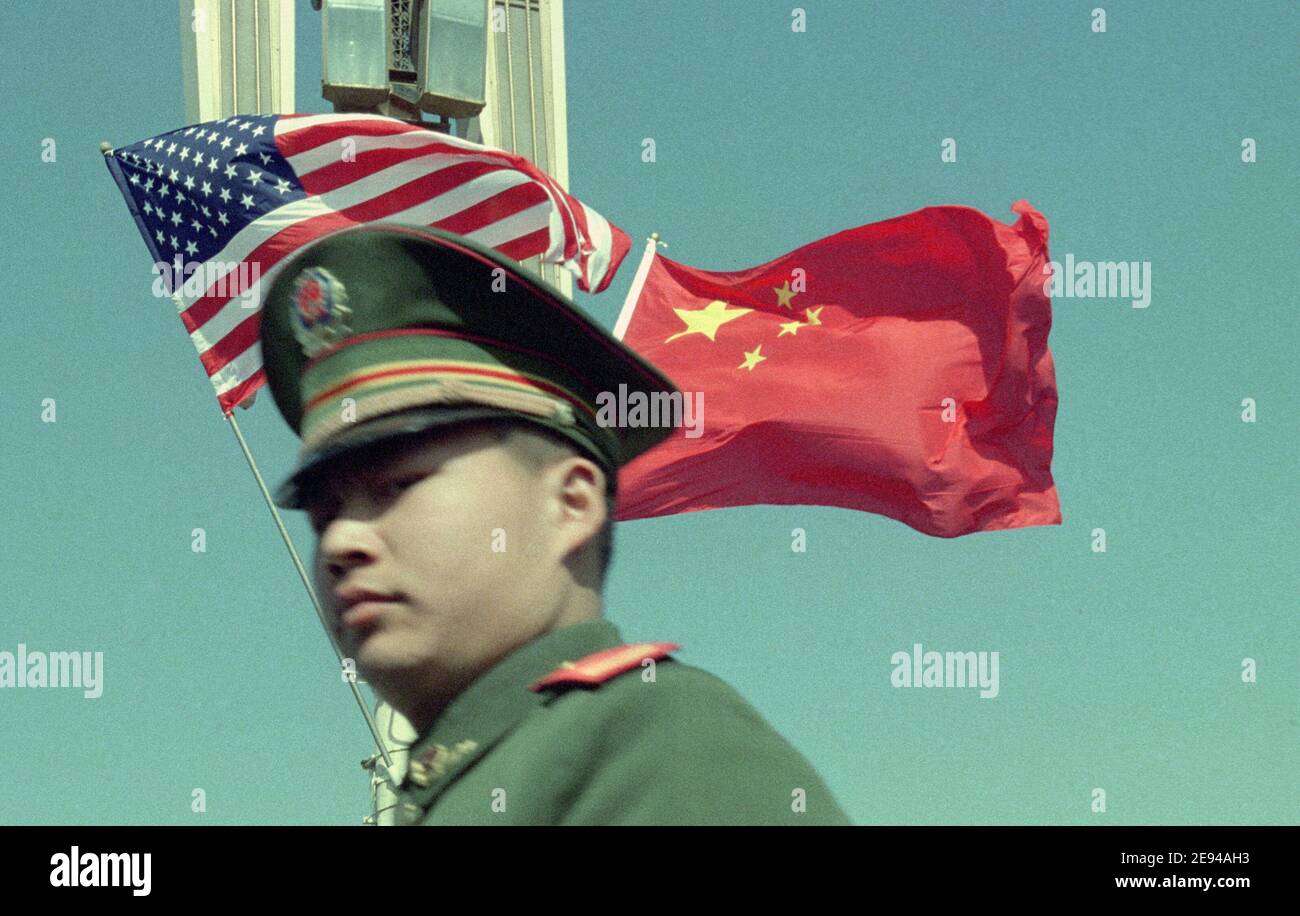 A Chinese armed police soldier walks past the Chinese and American ...
