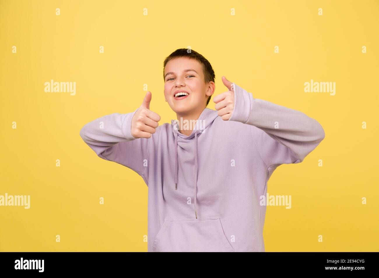 Thumbs up. Caucasian female portrait isolated on yellow studio ...