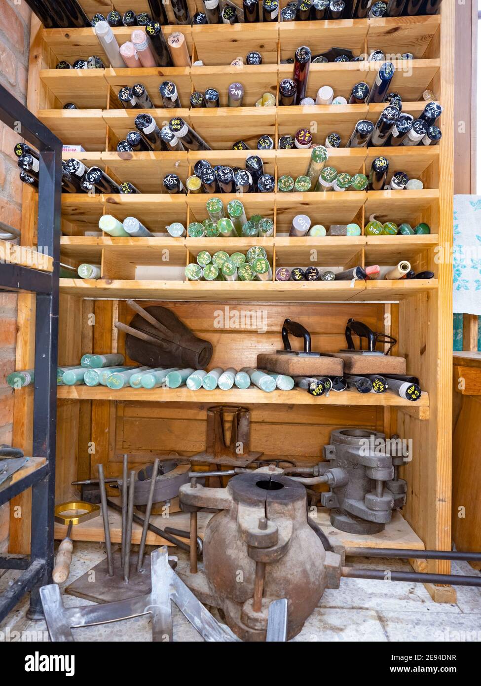 Glassy colorful rods. Wooden stand with pigment glass rods for work ...