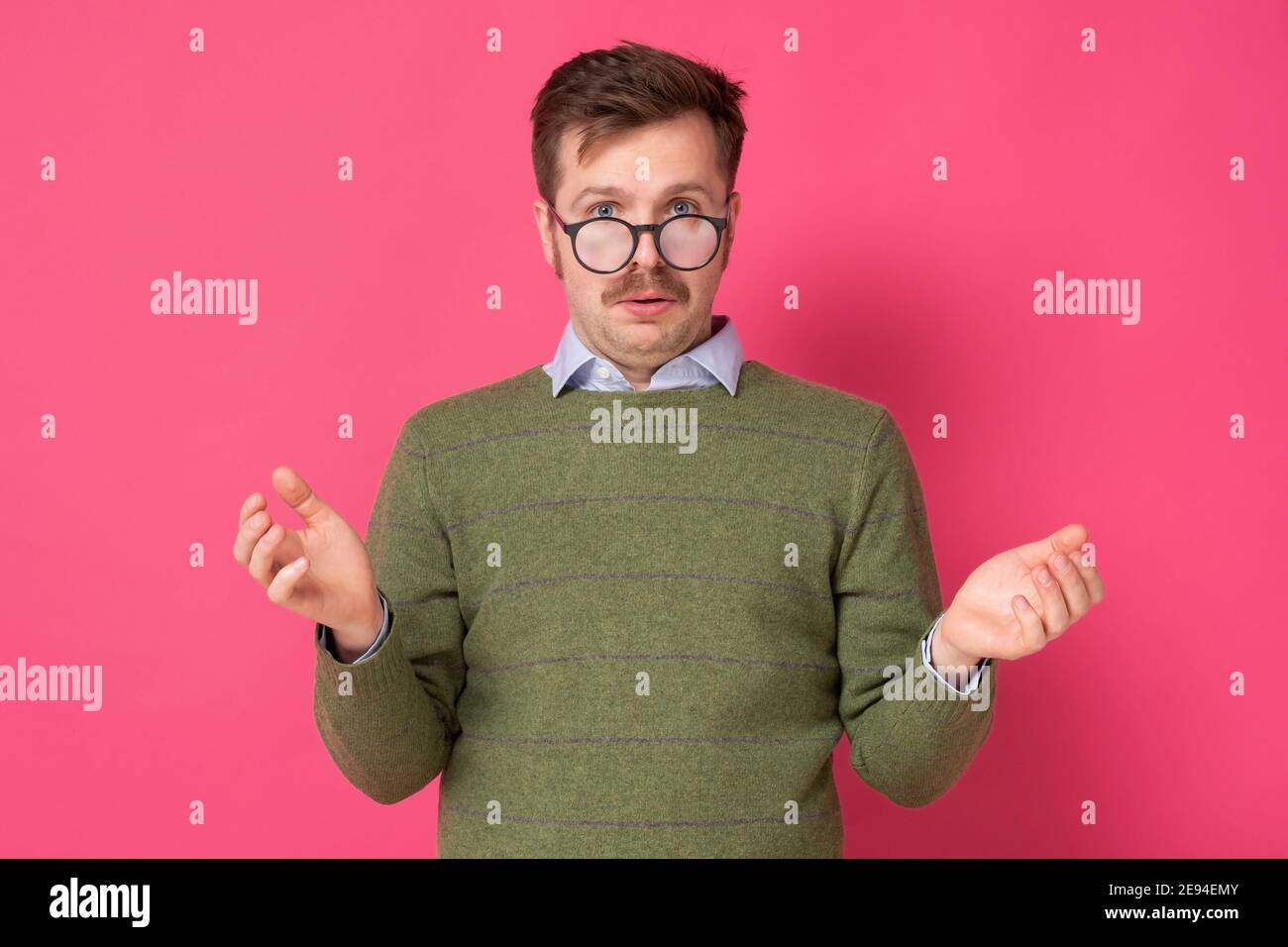 Studio shot of emotional clueless man with glasses having confused ...