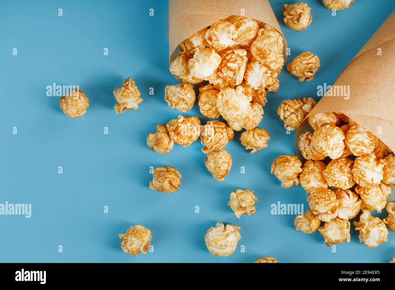 Caramel popcorn in a paper envelope on a blue background. Delicious ...