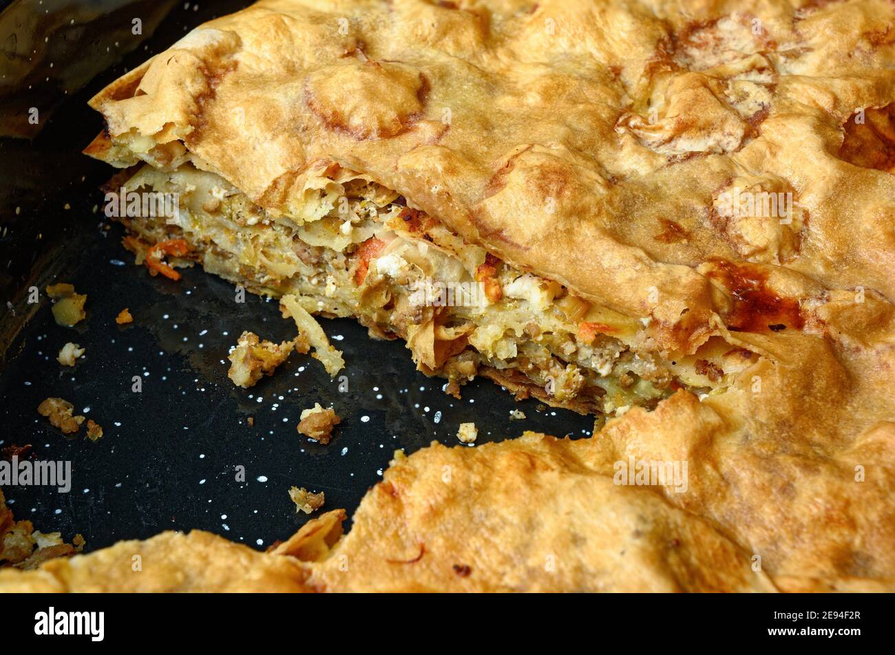 Delicious Greek Pontic-style homemade meat pie in black roasting pan ...