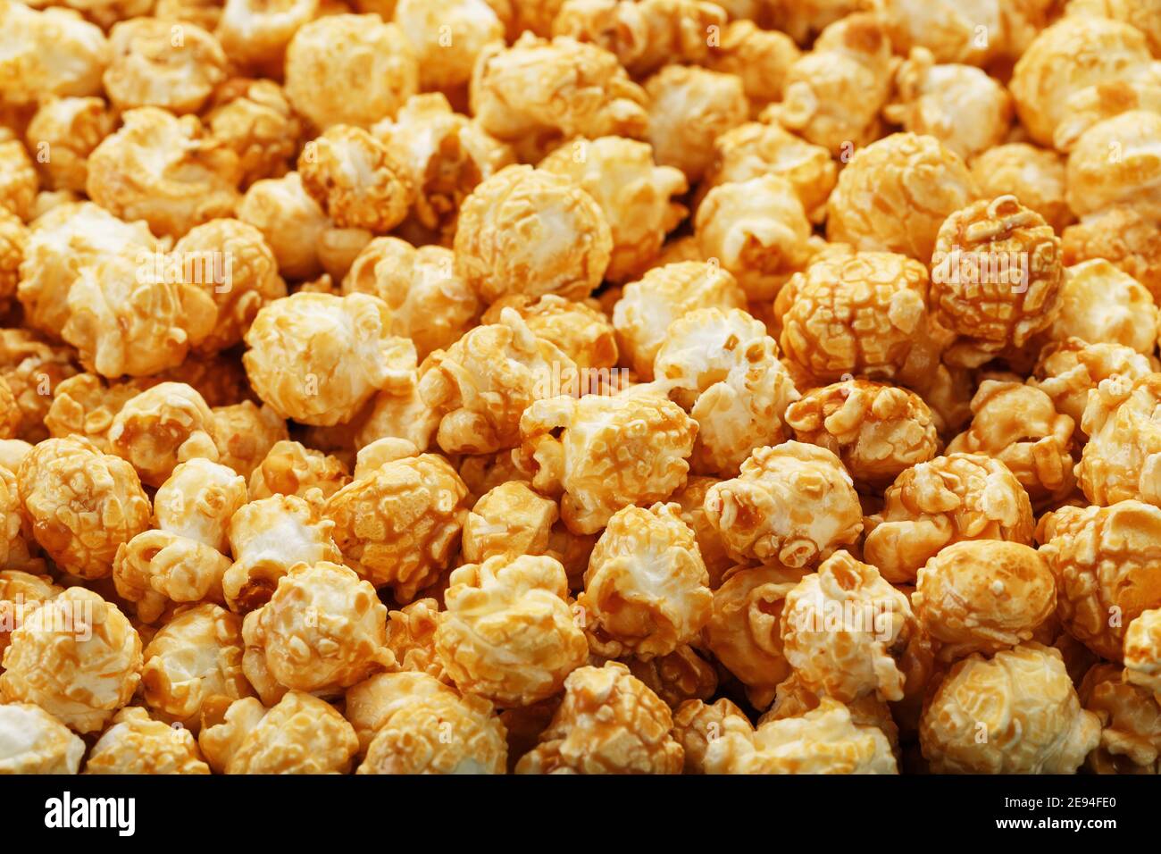 Popcorn in caramel glaze close-up as a background. Delicious praise for ...
