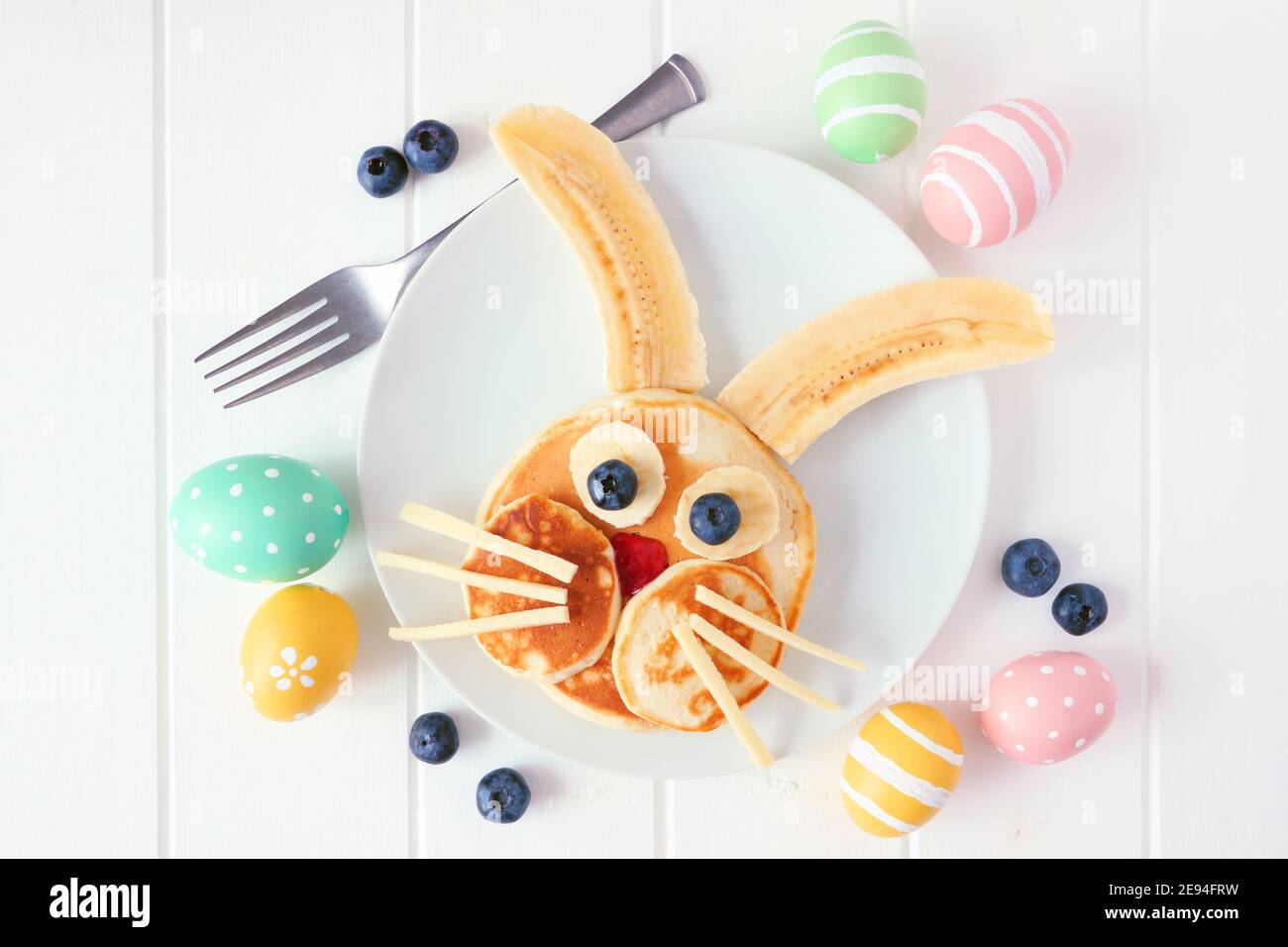 Cute Easter Bunny pancakes on a white plate. Flay lay against a white ...