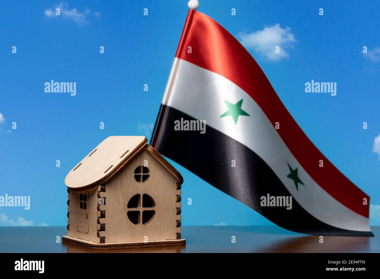 Small wooden house and Syria flag, sky on background. Real estate ...
