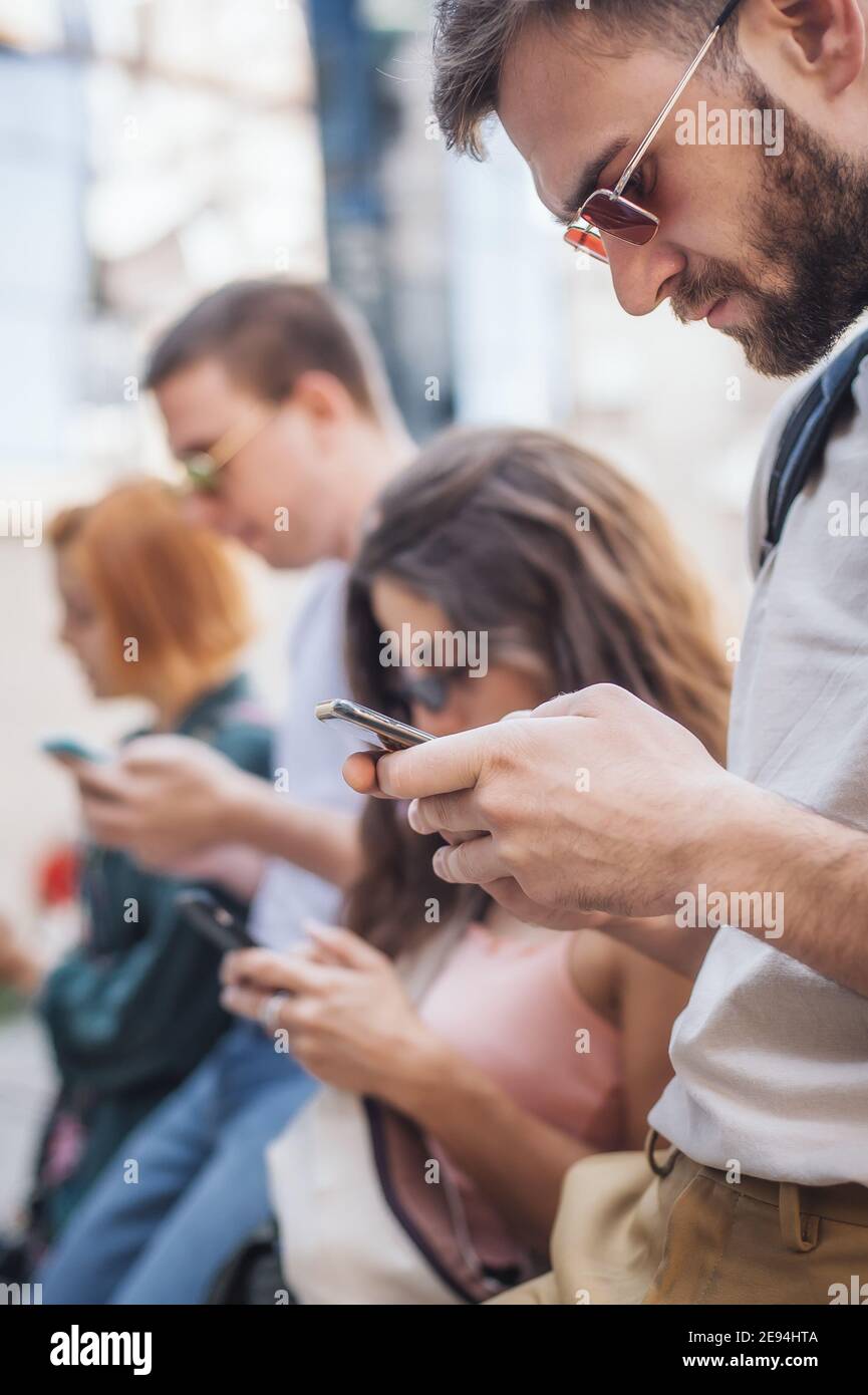 Group of friends using smartphones together. Young people addiction to ...