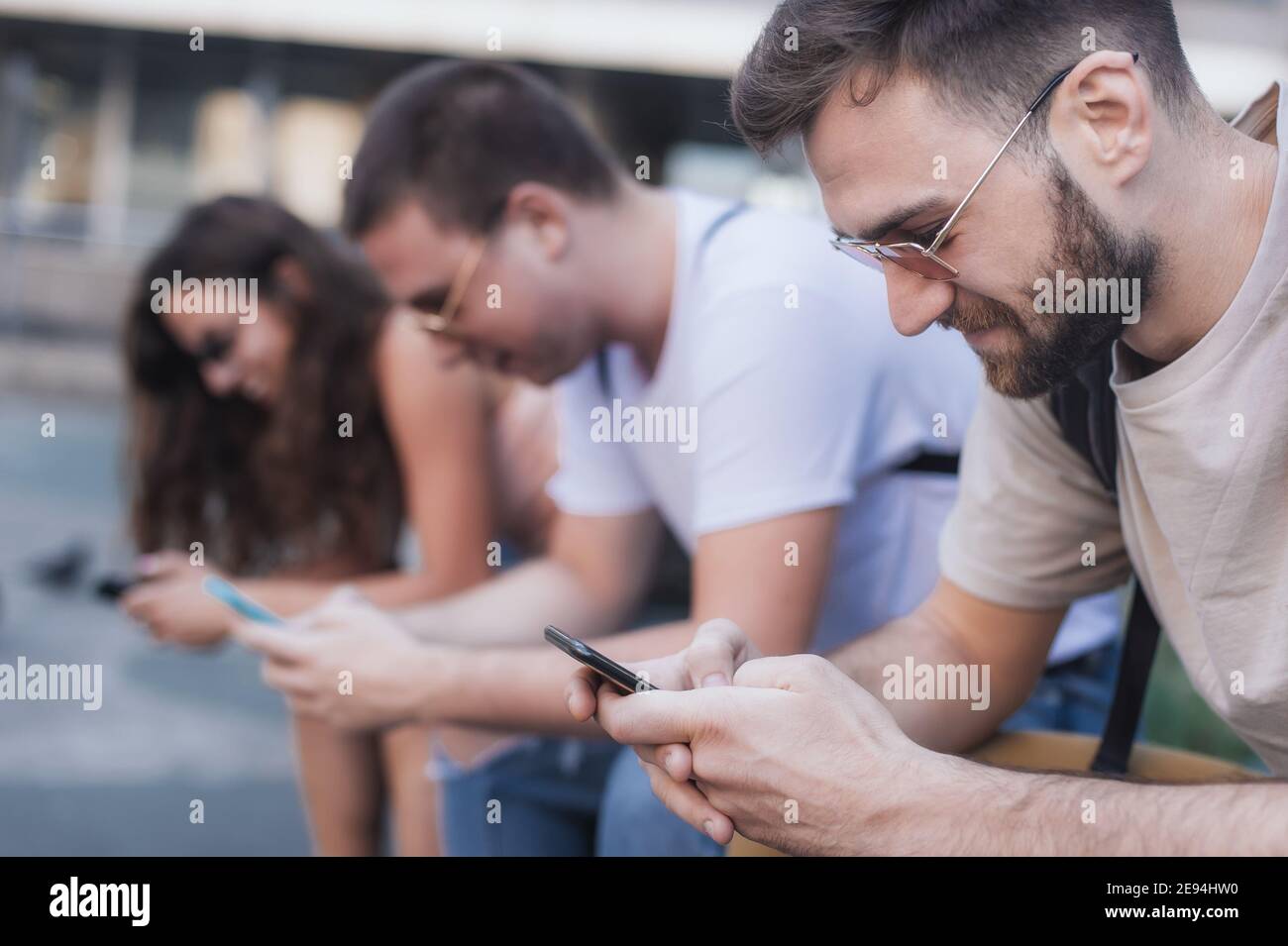 Group of friends using smartphones together. Young people addiction to ...