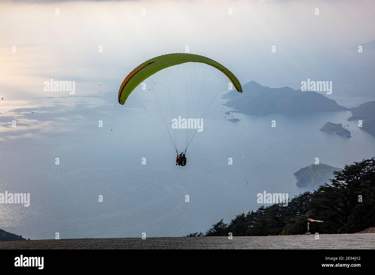 Paragliding in the sky. Paraglider tandem flying over the sea with ...