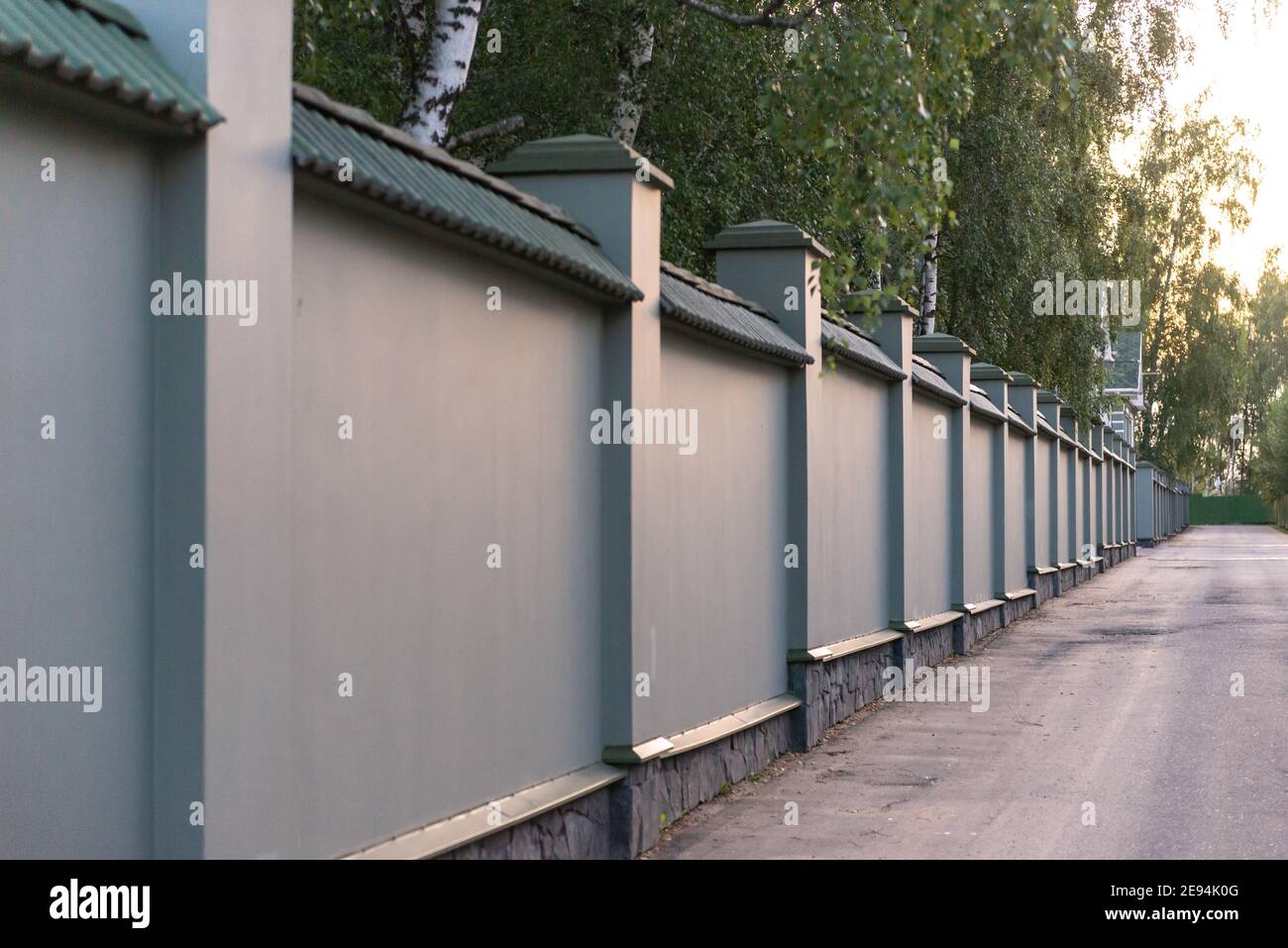 Solid concrete fence. Fence and paved road. Fenced territory, private ...