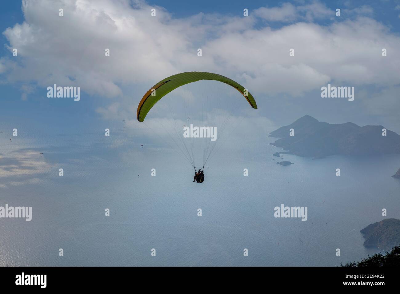 Paragliding in the sky. Paraglider tandem flying over the sea with ...