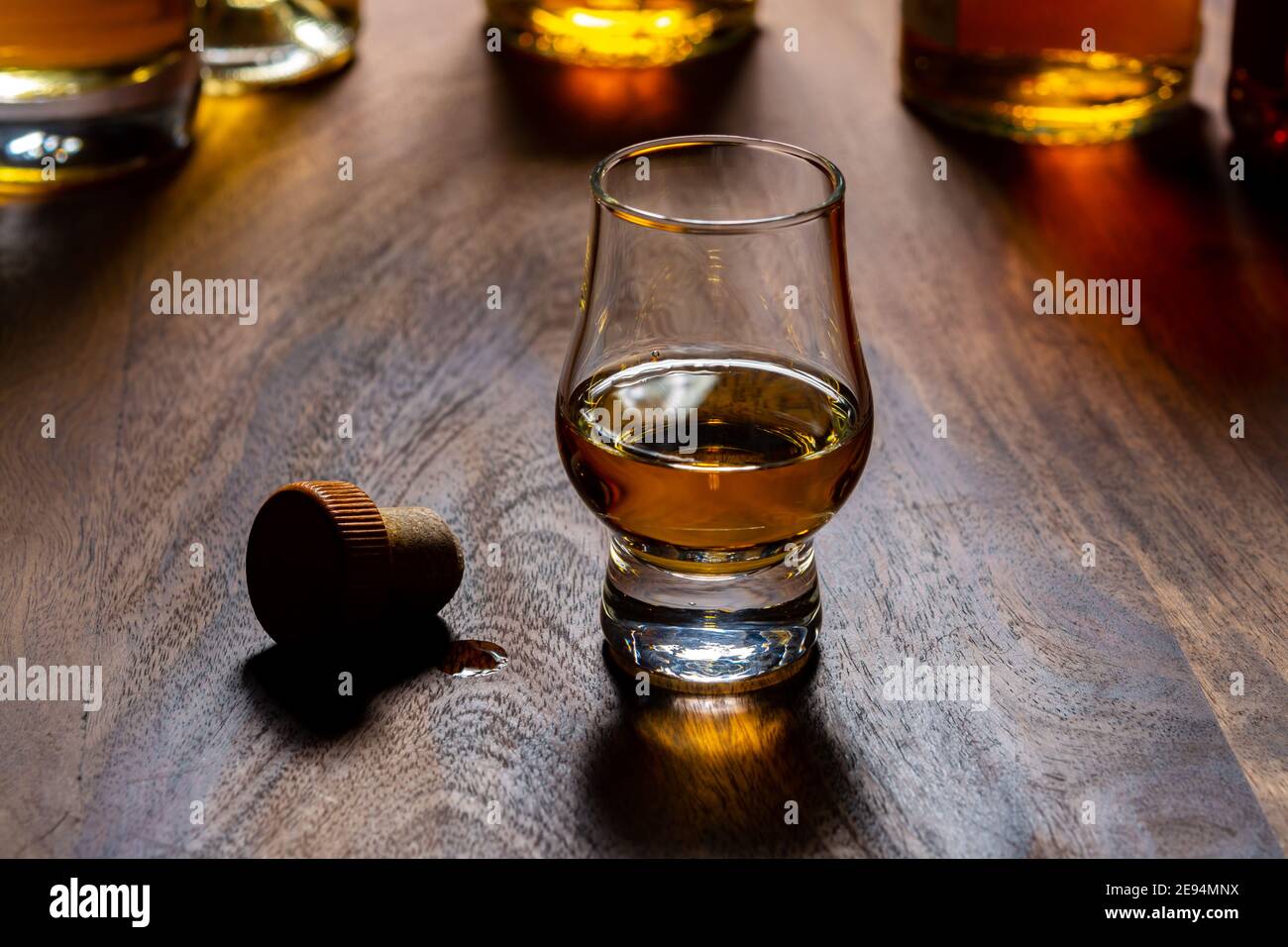 Dram of single malt scotch whisky and bottles on background, close up ...