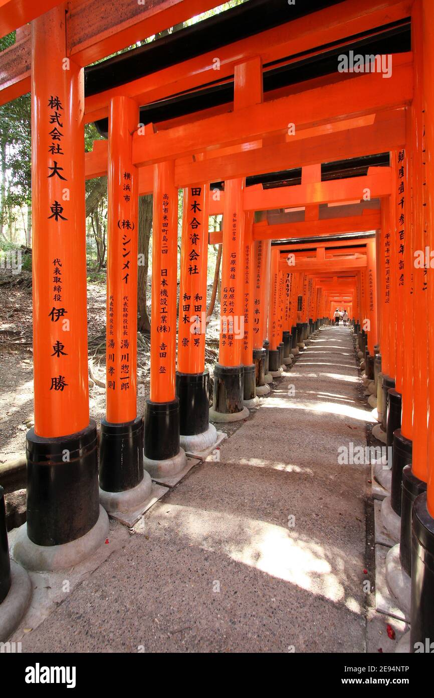 KYOTO, JAPAN - APRIL 18, 2012: People walk under tori gates in Fushimi ...