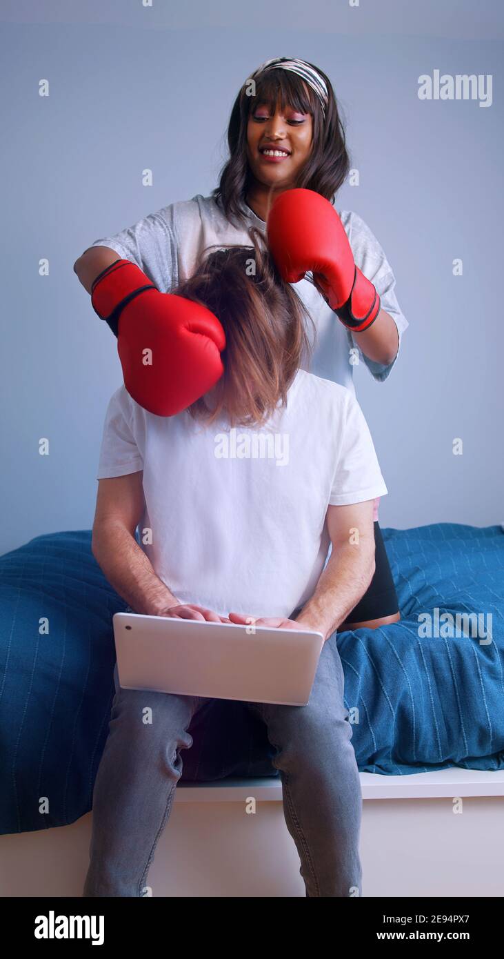 Woman with boxing gloves playing with boyfriends long hair trying to ...
