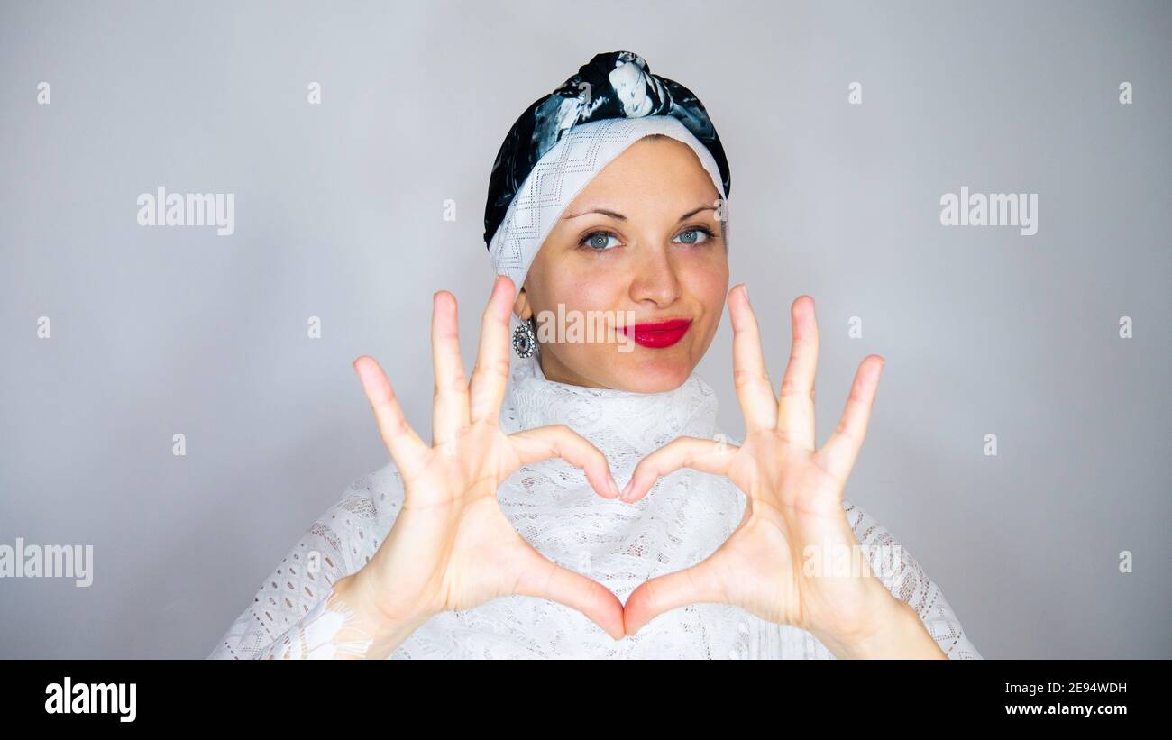 Muslim woman in white holding heart-shaped hands Stock Photo - Alamy