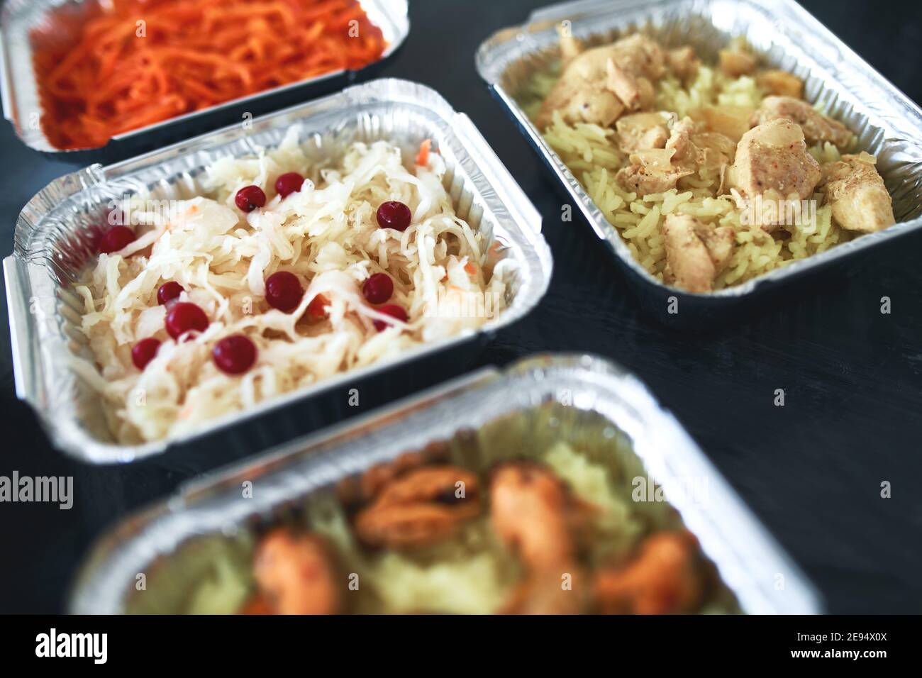 Different foil containers with delicious food Stock Photo - Alamy