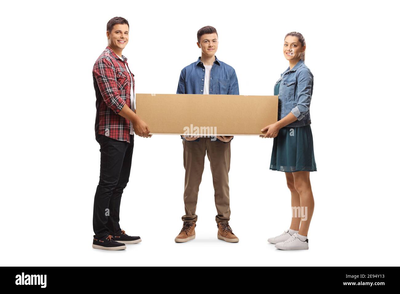 Three young people carrying a cardboard box together isolated on white ...