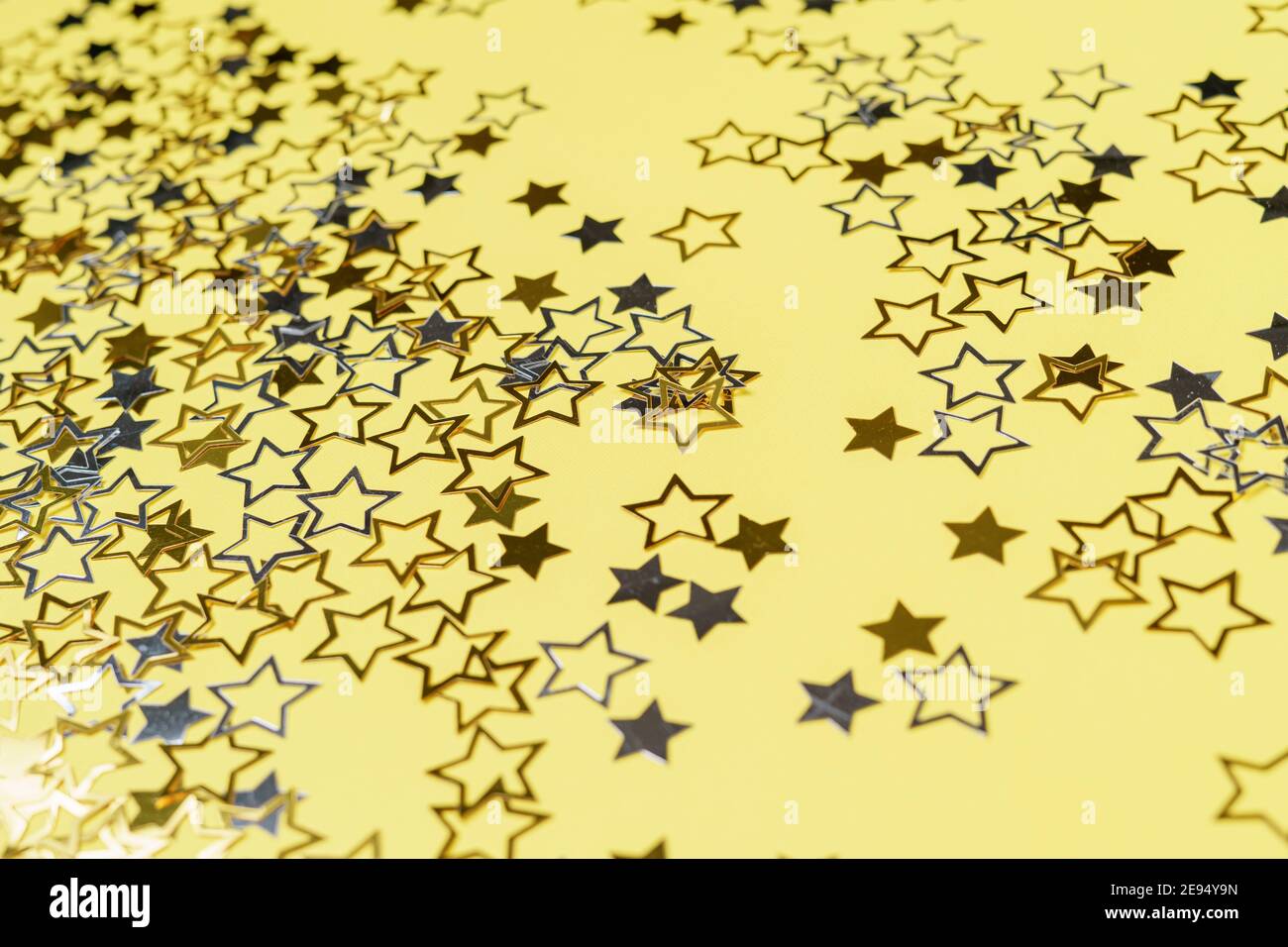 Gold and silver star dust sparkle on yellow. Chaotic cosmic background ...