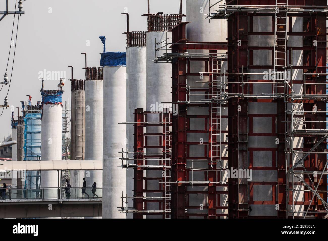 People walk on a pedestrian bridge along a major road. The Philippine ...