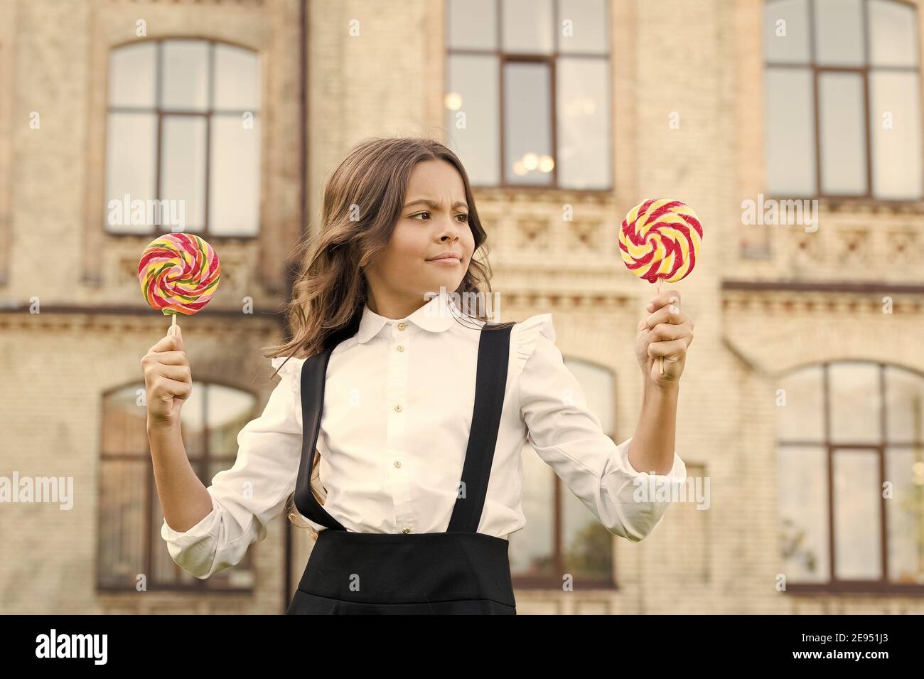 Schoolgirl choosing sweets. Happy kid with sweet candy. Kid child ...