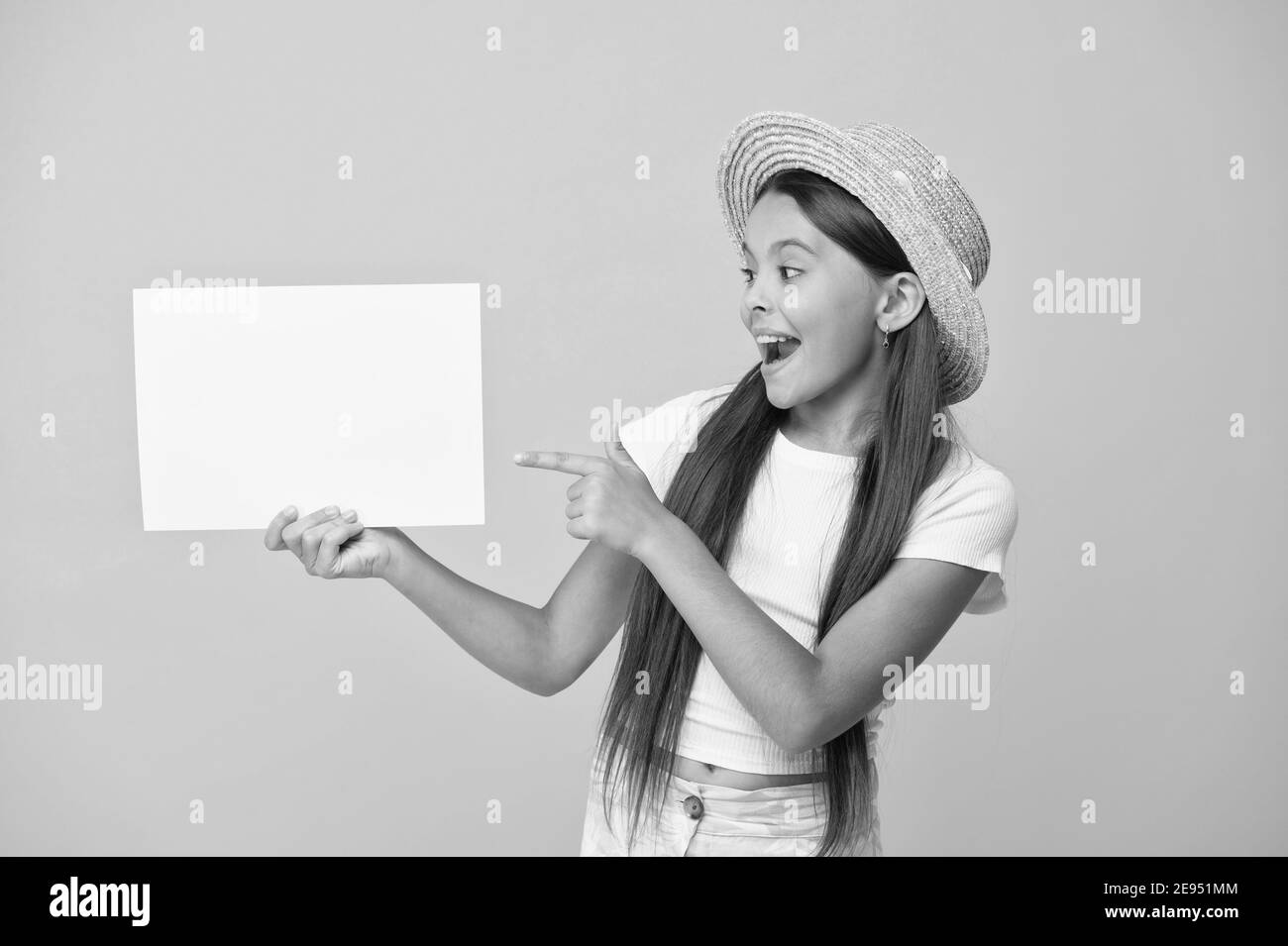 Little girl straw hat presenting poster advertisement copy space ...