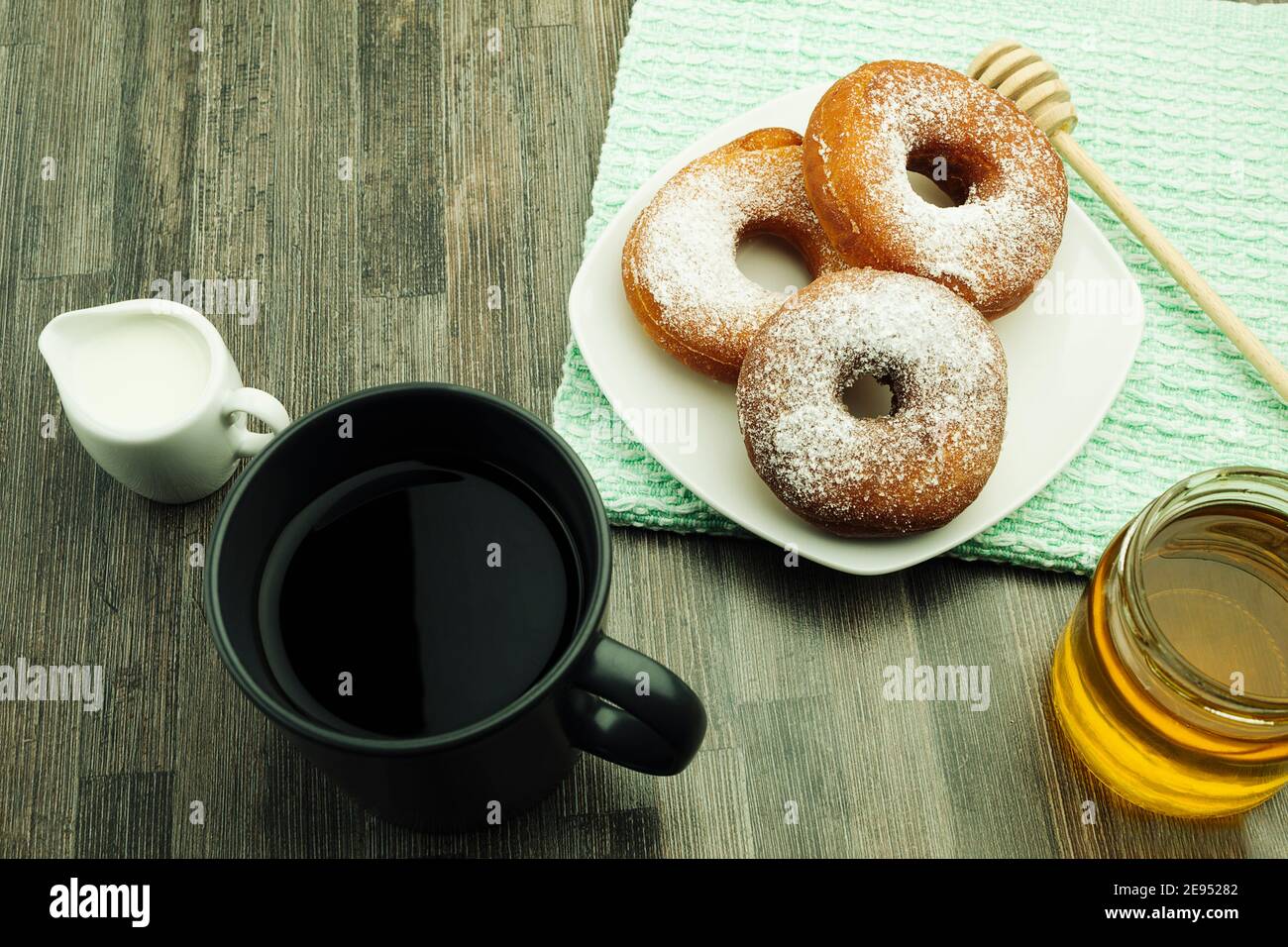 Donut and coffee with milk for breakfast. Round donuts in sugar on a ...