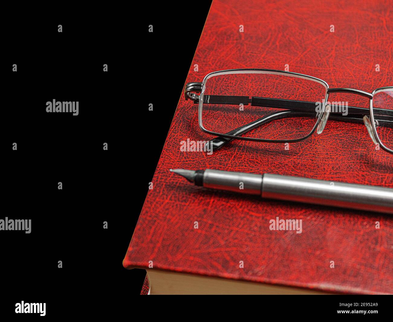 Book with glasses on a yellow background. Finished book. Closed red and ...