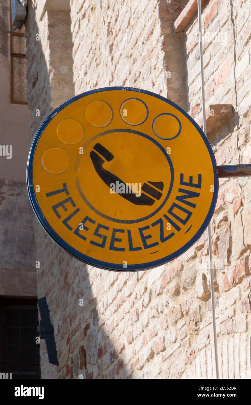 Vertical shot of a yellow sign with an Italian text and symbol of a ...