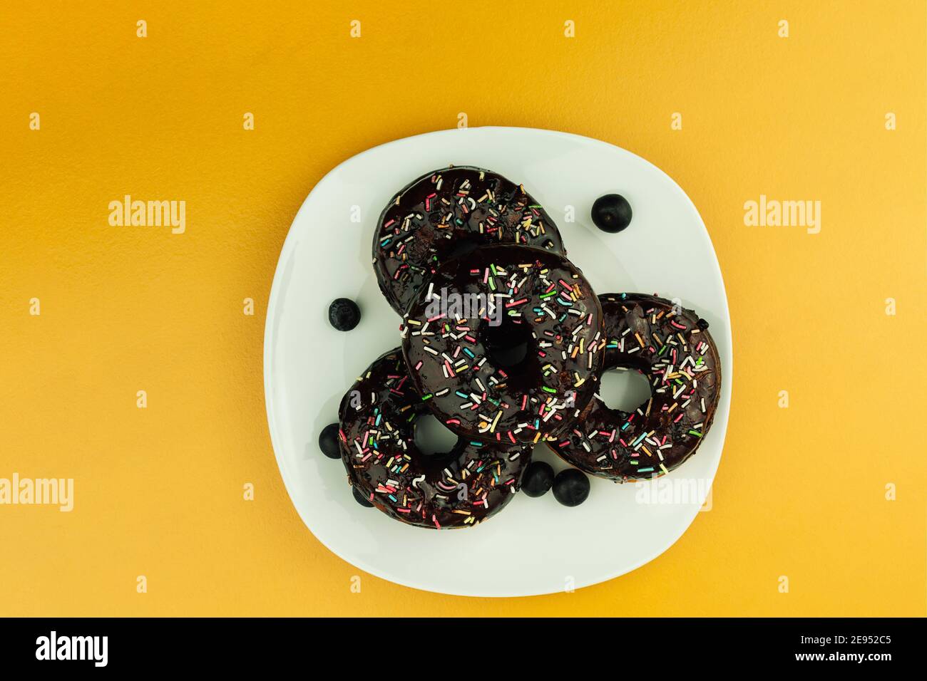 Round donuts on a square and white plate. Background with empty space ...