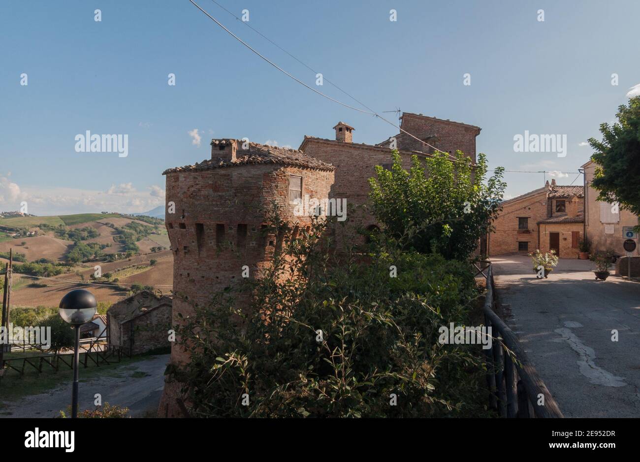 Brick castle next to a street and with the view of green hills Stock ...
