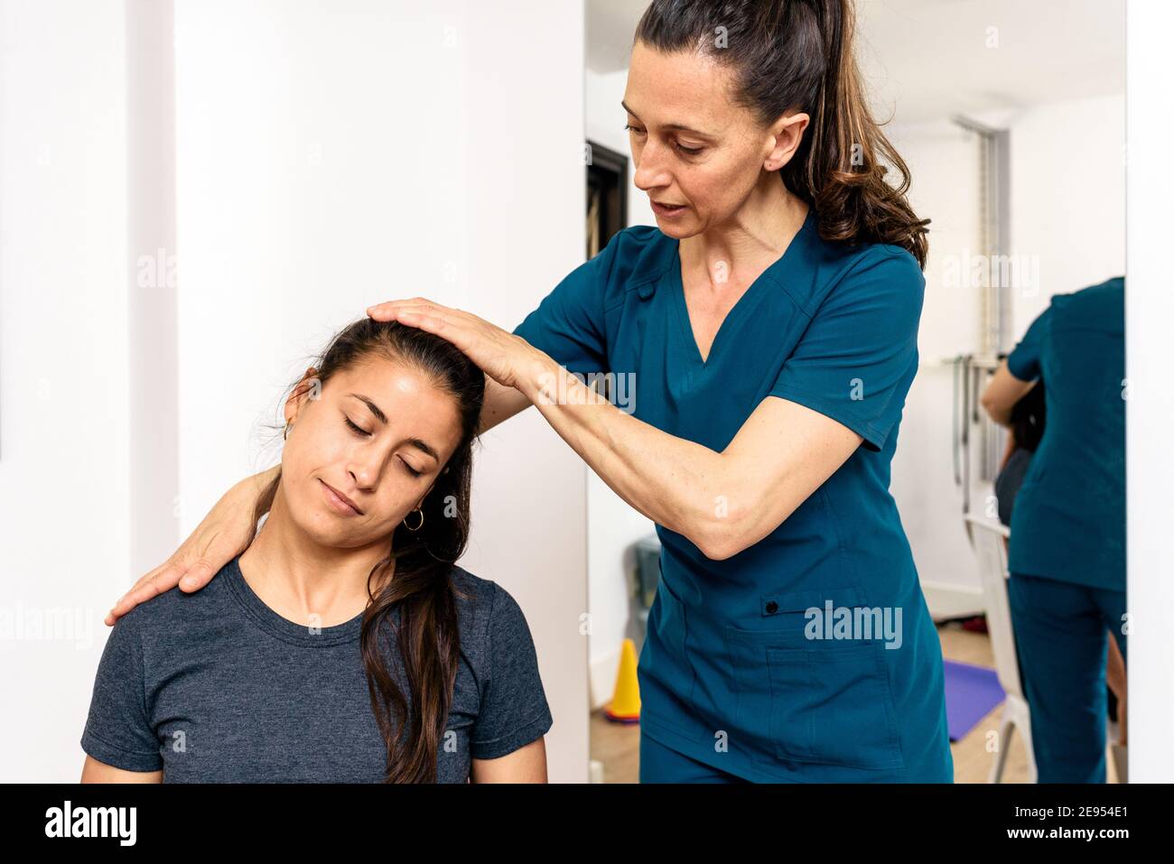 Stock photo of physiotherapist giving neck massage to patient sitting ...