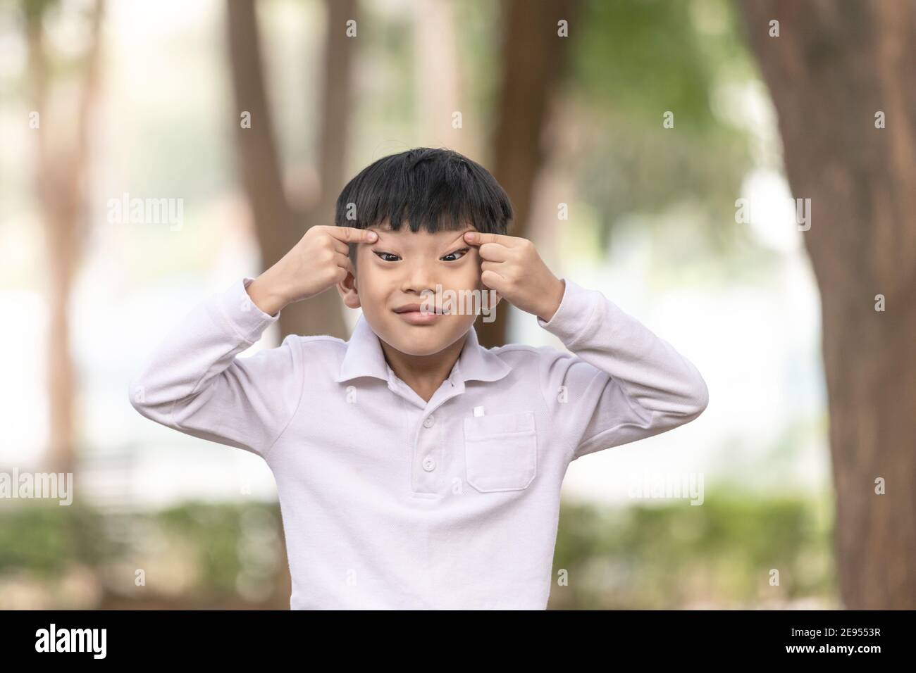 Asian child enjoying making a funny face. A boy with a cheeky face ...