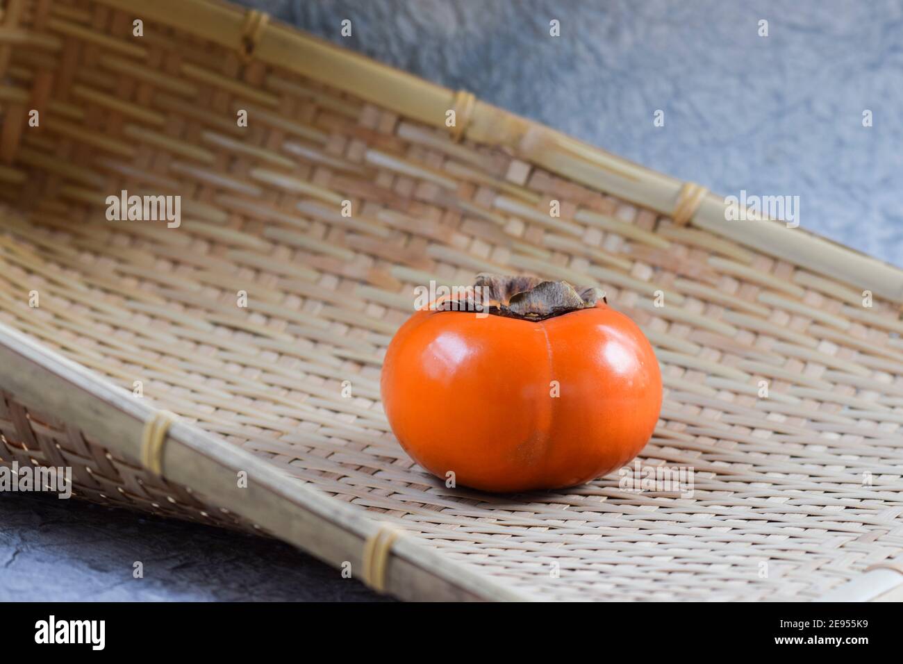 Closeup of fresh persimmon fruit which bright red orange in color. It ...