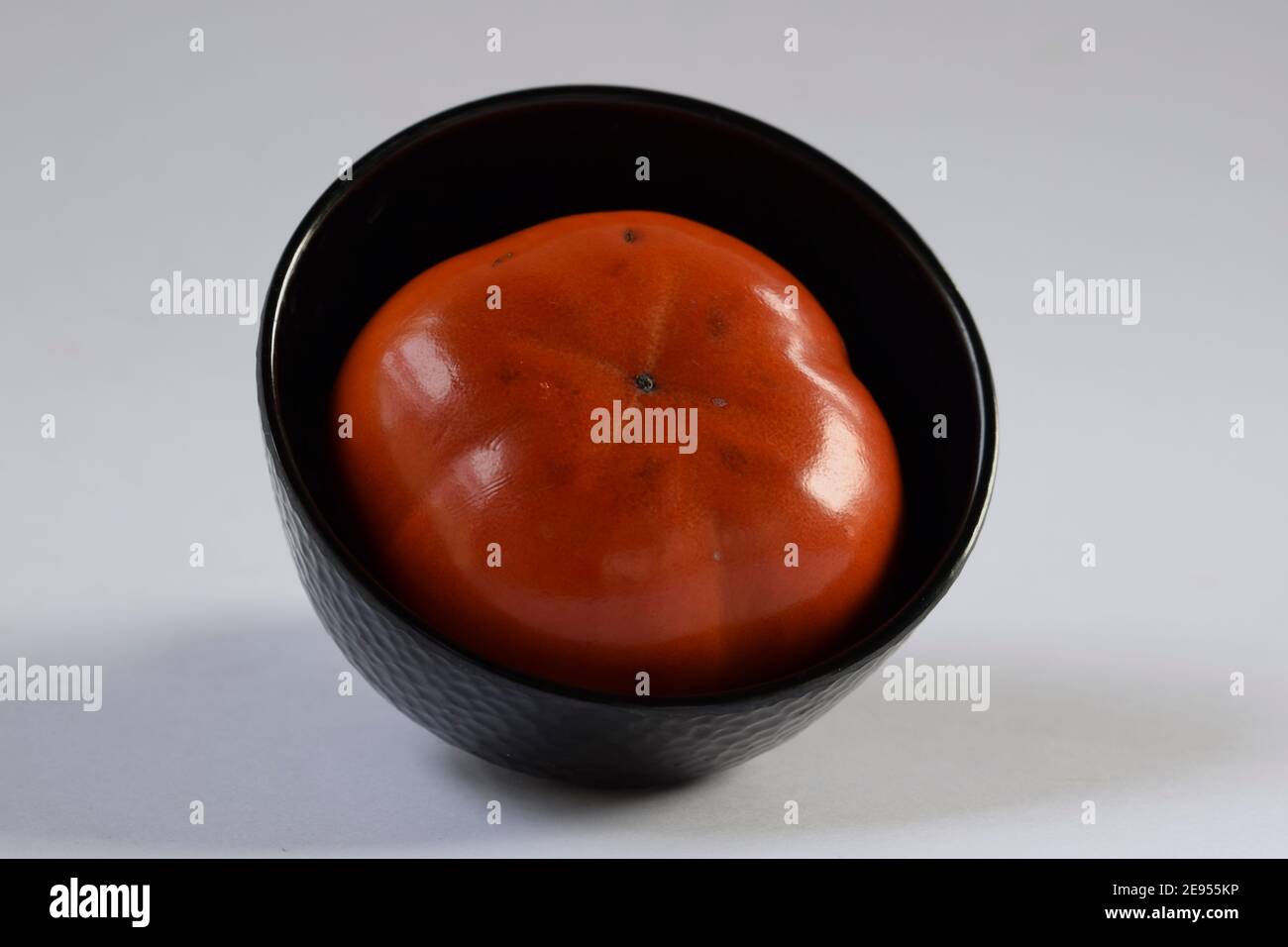 Closeup of fresh persimmon fruit which bright red orange in color. It ...