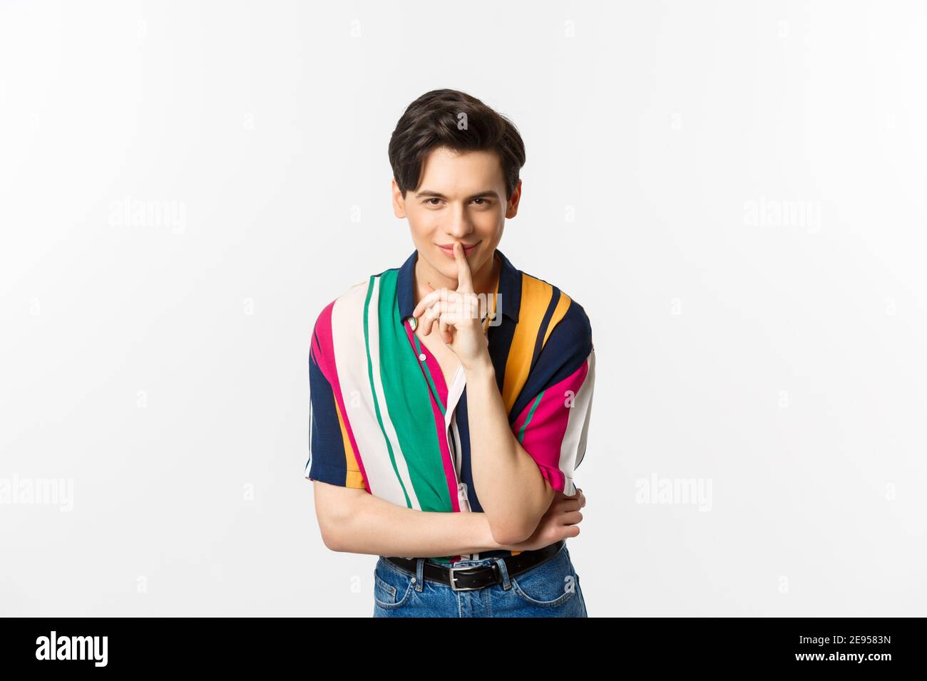 Portrait of young handsome man prepare surprise, hushing and smiling ...