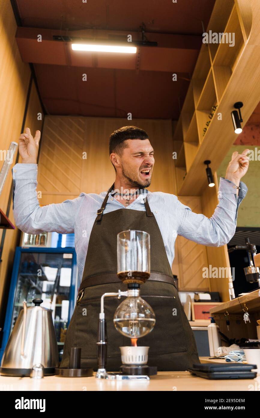 Syphon coffee device with fire heats glass flask in cafe. Emotional ...
