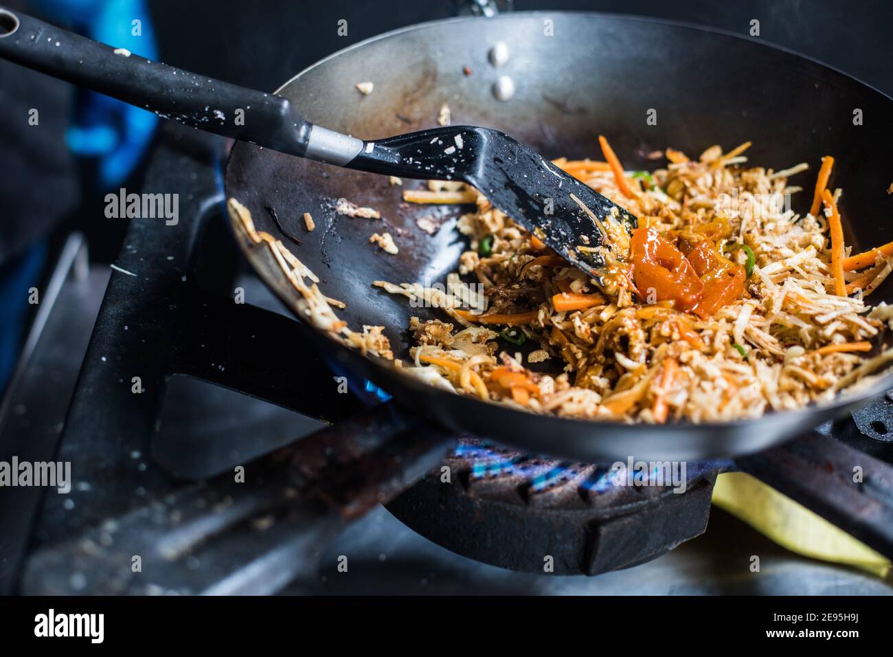 Detail of a pan with vegetables and an egg being mixed and cooked ...