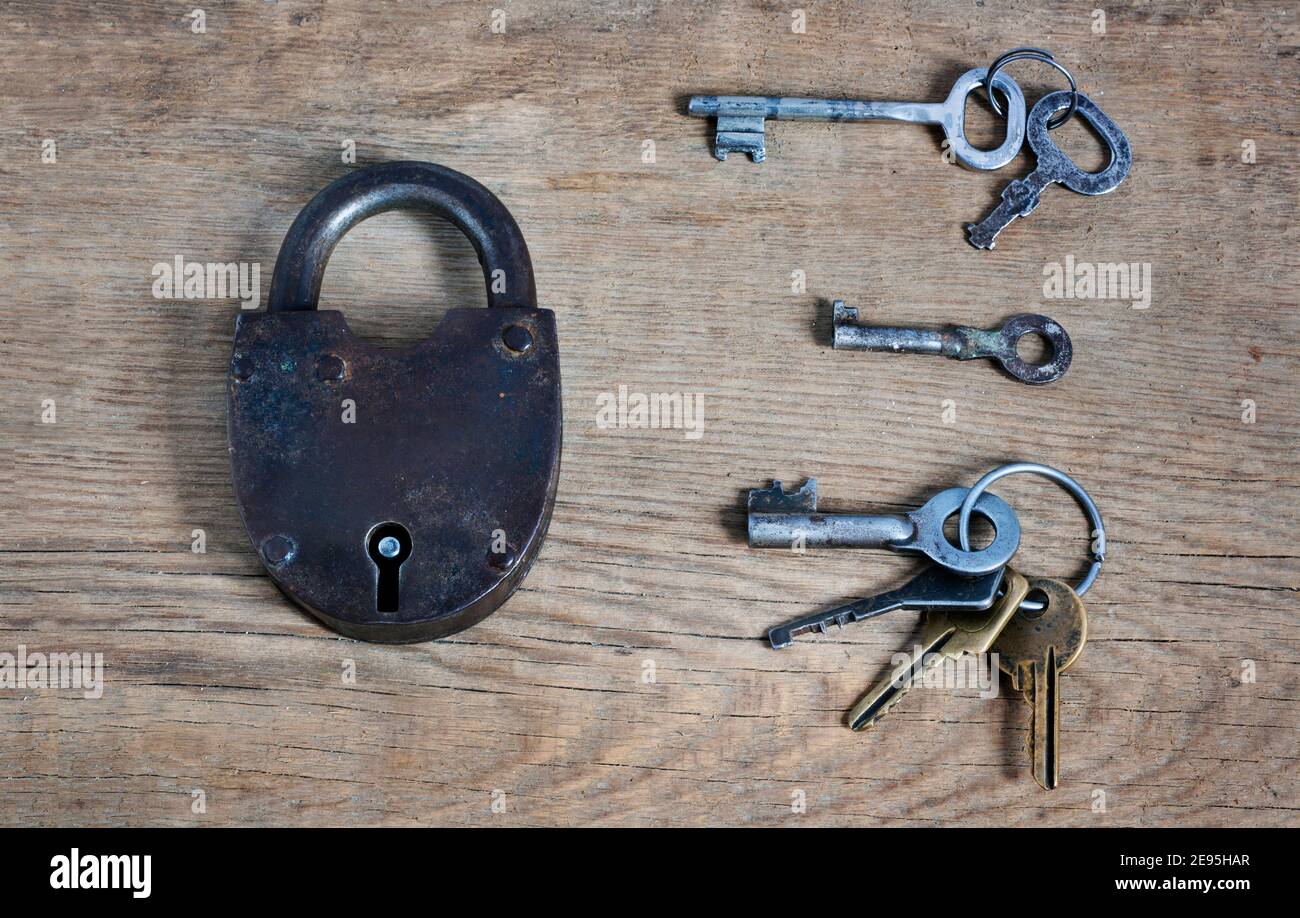 old fashioned rusty lock with keys on wooden surface Stock Photo - Alamy