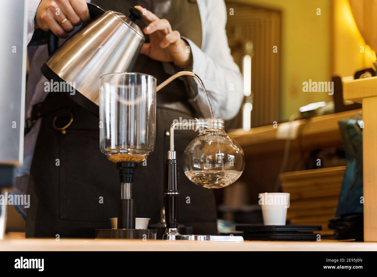 Syphon alternative method of making coffee. Barista pours hot boiling ...